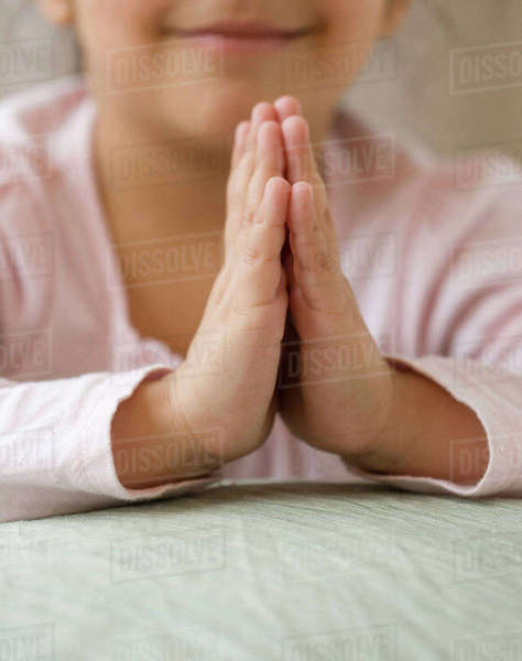 Hispanic girl praying - Stock Photo - Dissolve