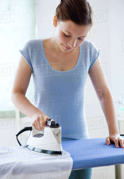 Teenage girl ironing clothes - Royalty-free Stock Photo | Dissolve