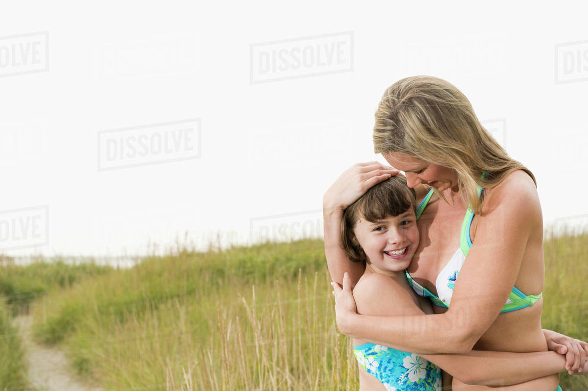 Portrait of mother hugging daughter on beach - Royalty-free Stock Photo | Dissolve