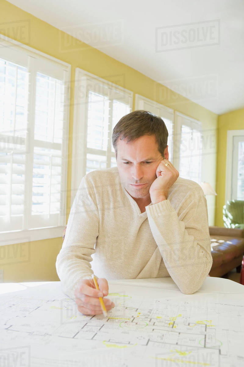 Man reviewing house blueprints - Royalty-free Stock Photo | Dissolve