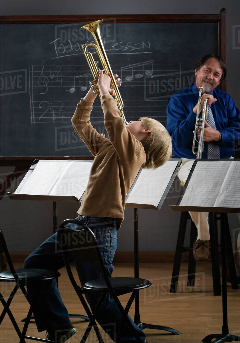 Boy playing trumpet in classroom - Royalty-free Stock Photo | Dissolve