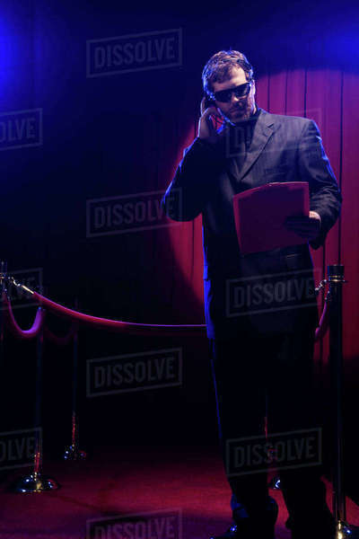 Bouncer looking at guest list - Royalty-free Stock Photo | Dissolve