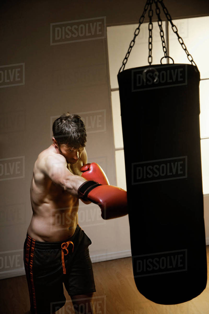 Boxer training with punching bag - Royalty-free Stock Photo | Dissolve
