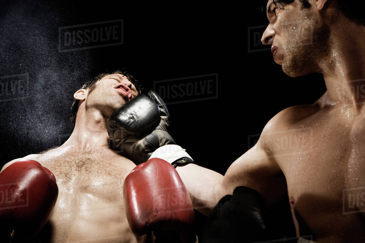 Boxer punching opponent in jaw - Royalty-free Stock Photo | Dissolve