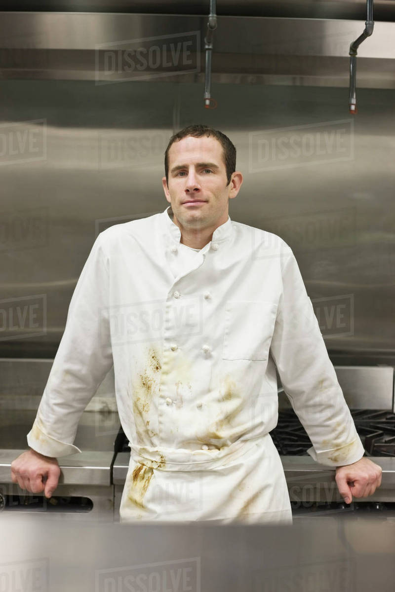 Dirty chef leaning against stove - Royalty-free Stock Photo | Dissolve