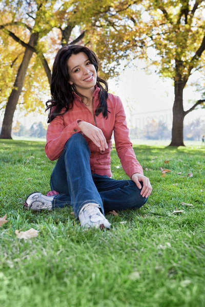 Woman sitting in grass - Stock Photo - Dissolve