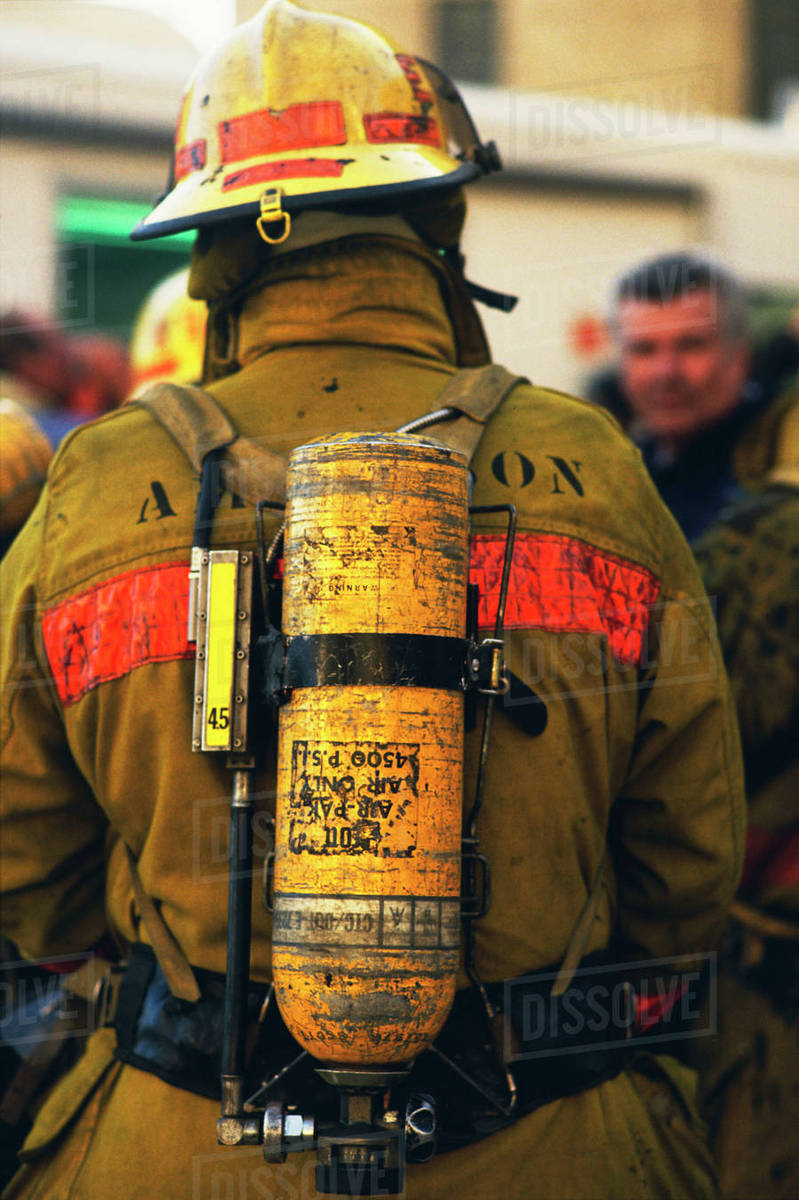 Rear view of fireman wearing oxygen tank - Royalty-free Stock Photo ...