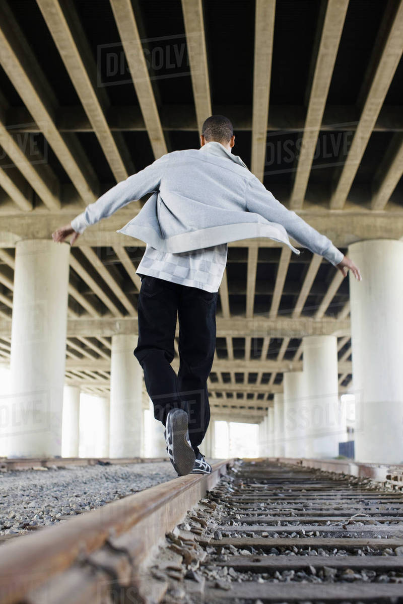 Man balancing on railroad tracks - Royalty-free Stock Photo | Dissolve