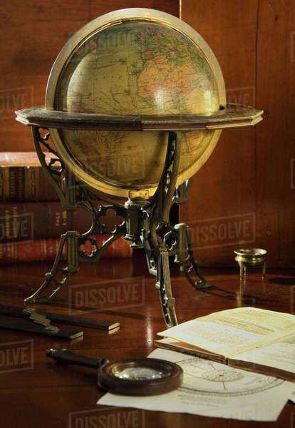 Old fashioned globe in stand on table - Stock Photo - Dissolve