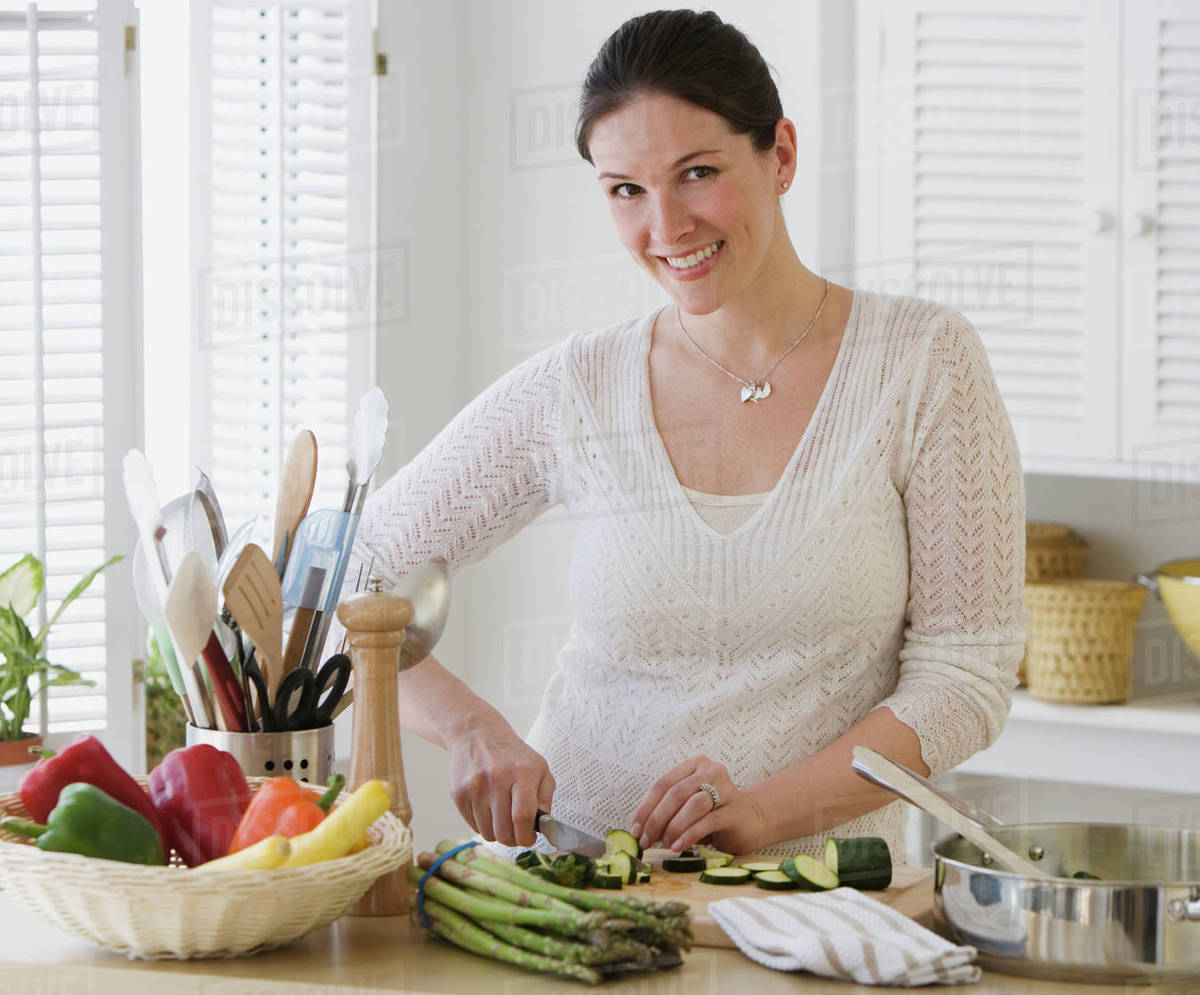 Woman chopping vegetables in kitchen - Stock Photo - Dissolve