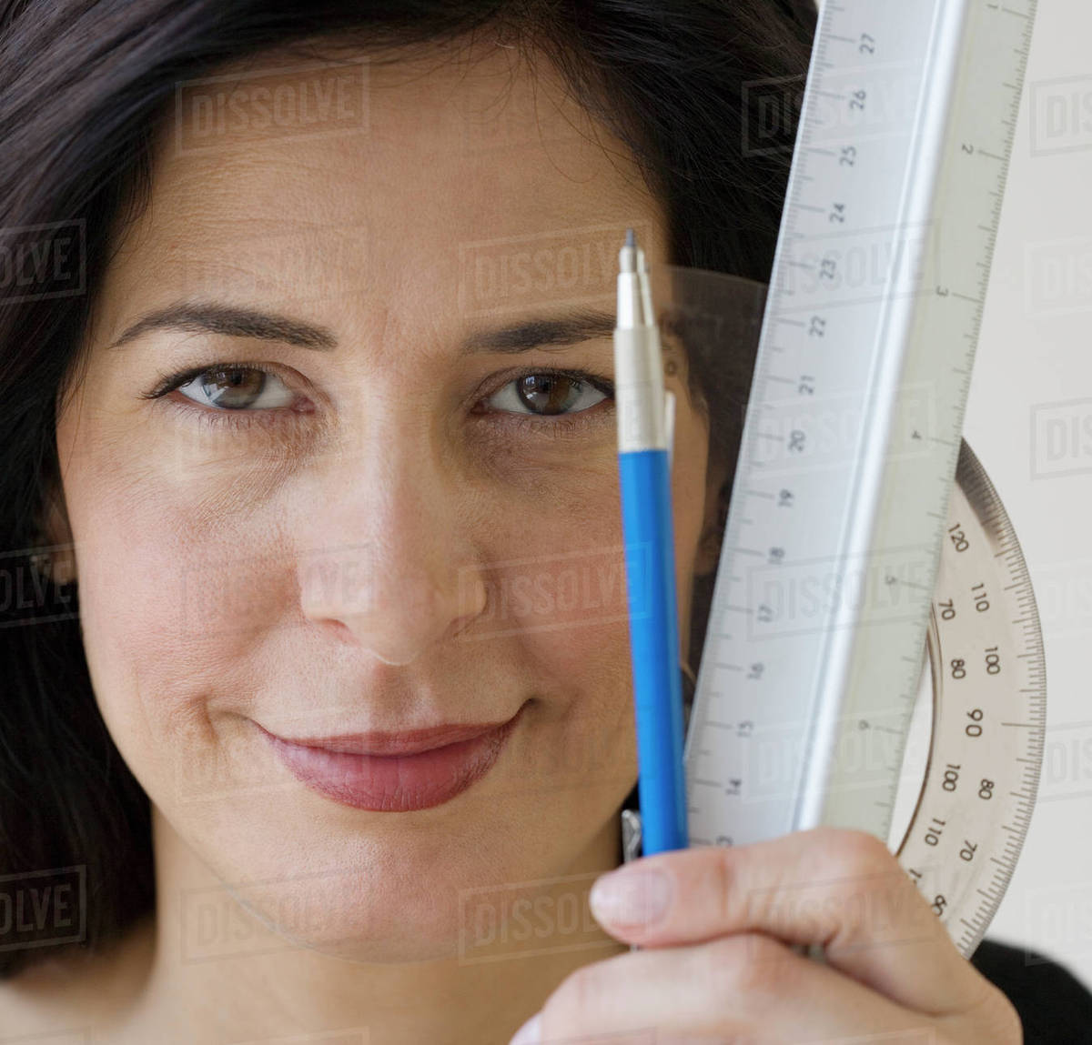 Woman holding ruler, protractor and pencil - Stock Photo - Dissolve