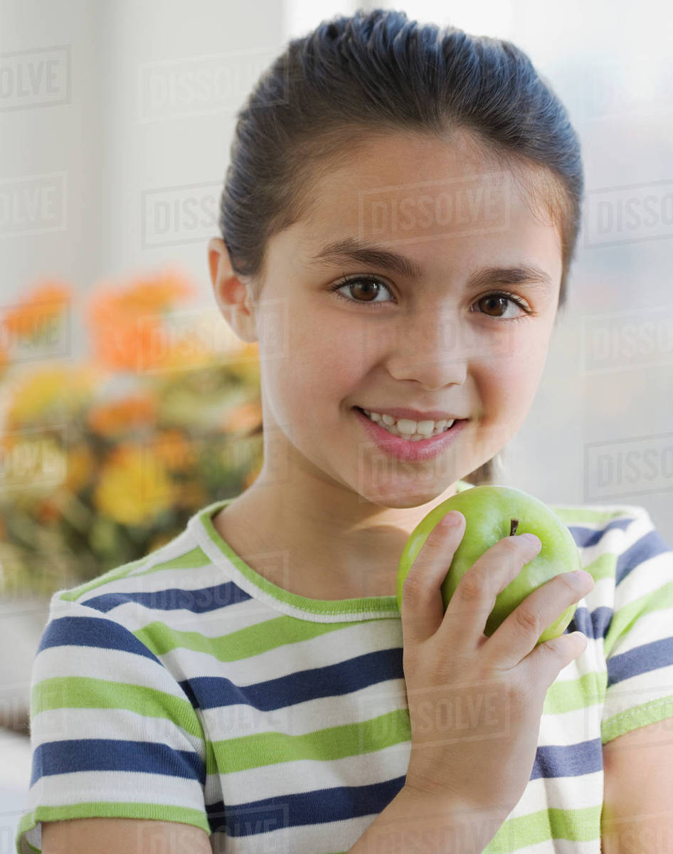 Close up of girl holding apple - Royalty-free Stock Photo | Dissolve