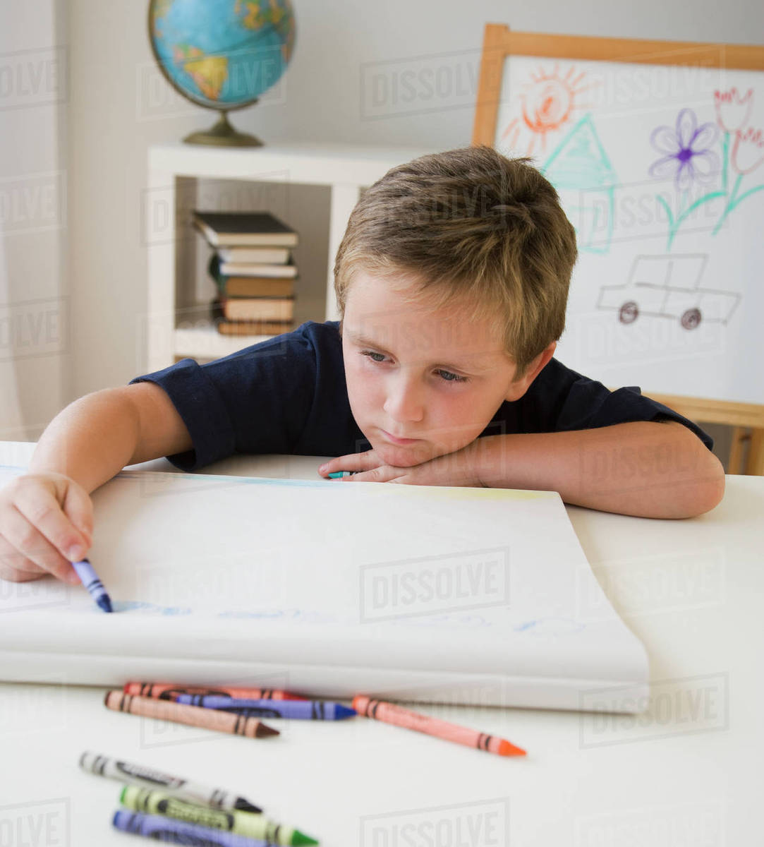Boy coloring at table - Royalty-free Stock Photo | Dissolve
