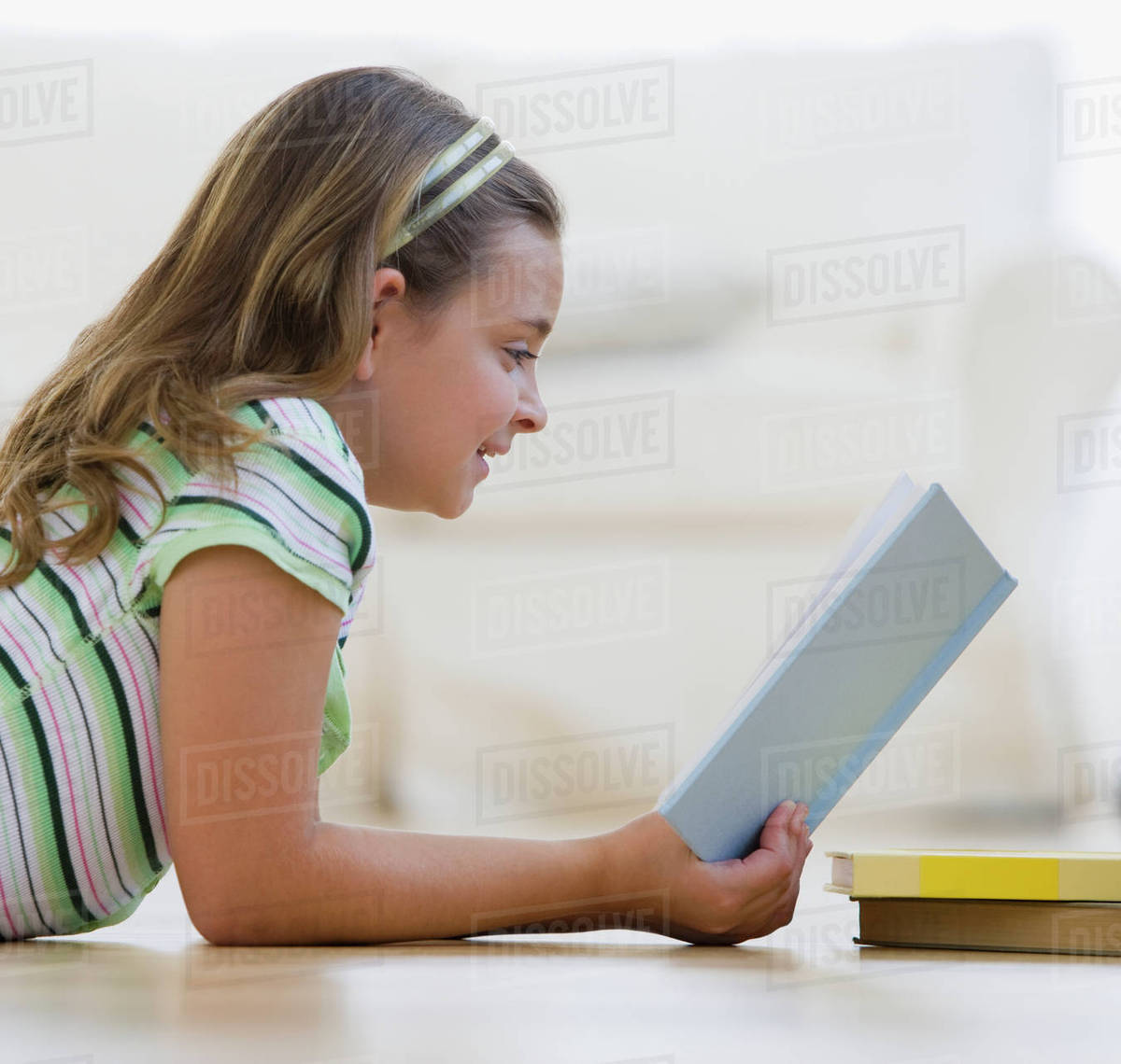Girl reading on floor - Stock Photo - Dissolve