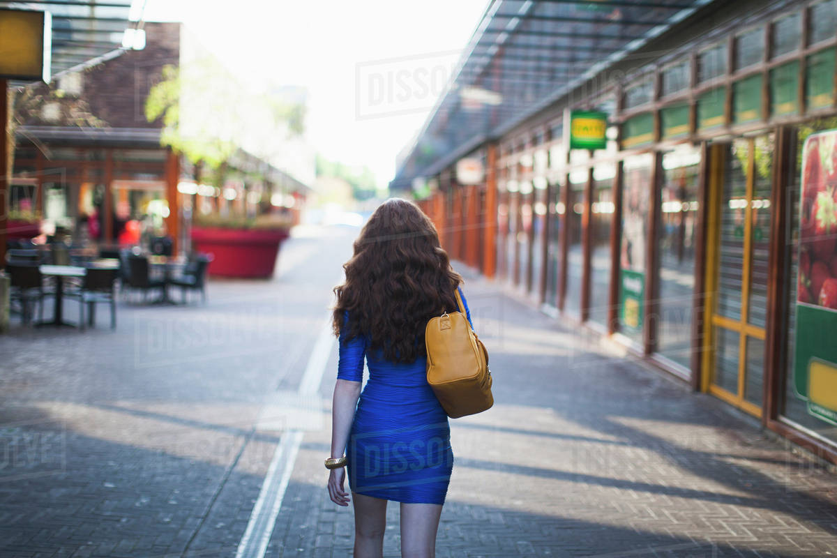 Rear view of walking elegant woman - Stock Photo - Dissolve