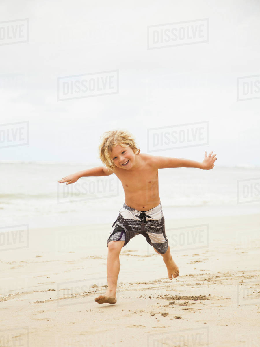 Boy (6-7) playing on beach - Royalty-free Stock Photo | Dissolve