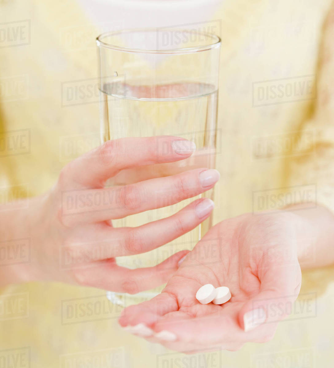 Woman holding water and medication - Royalty-free Stock Photo | Dissolve