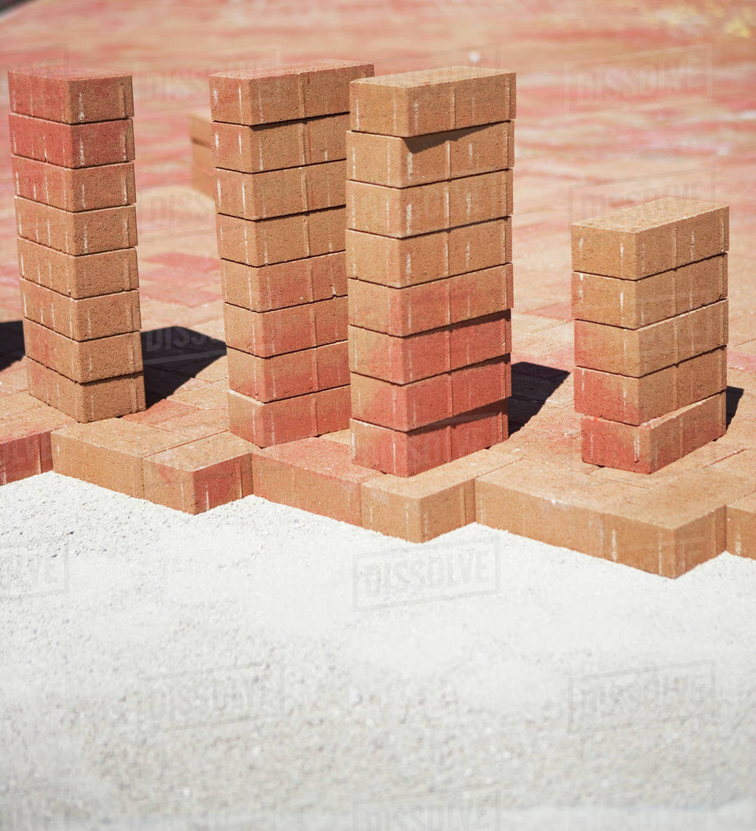 Stacks of bricks on edge of new patio - Royalty-free Stock Photo | Dissolve