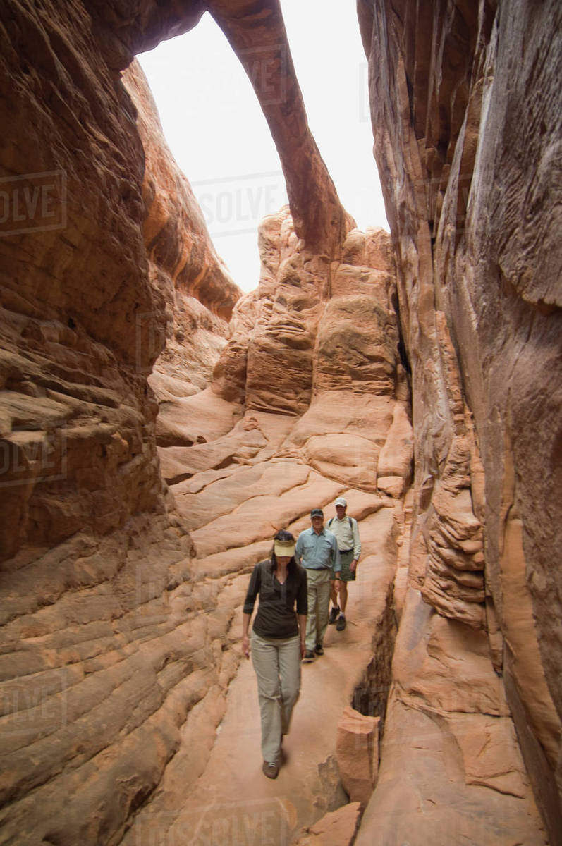 People looking up at rock formations - Royalty-free Stock Photo | Dissolve