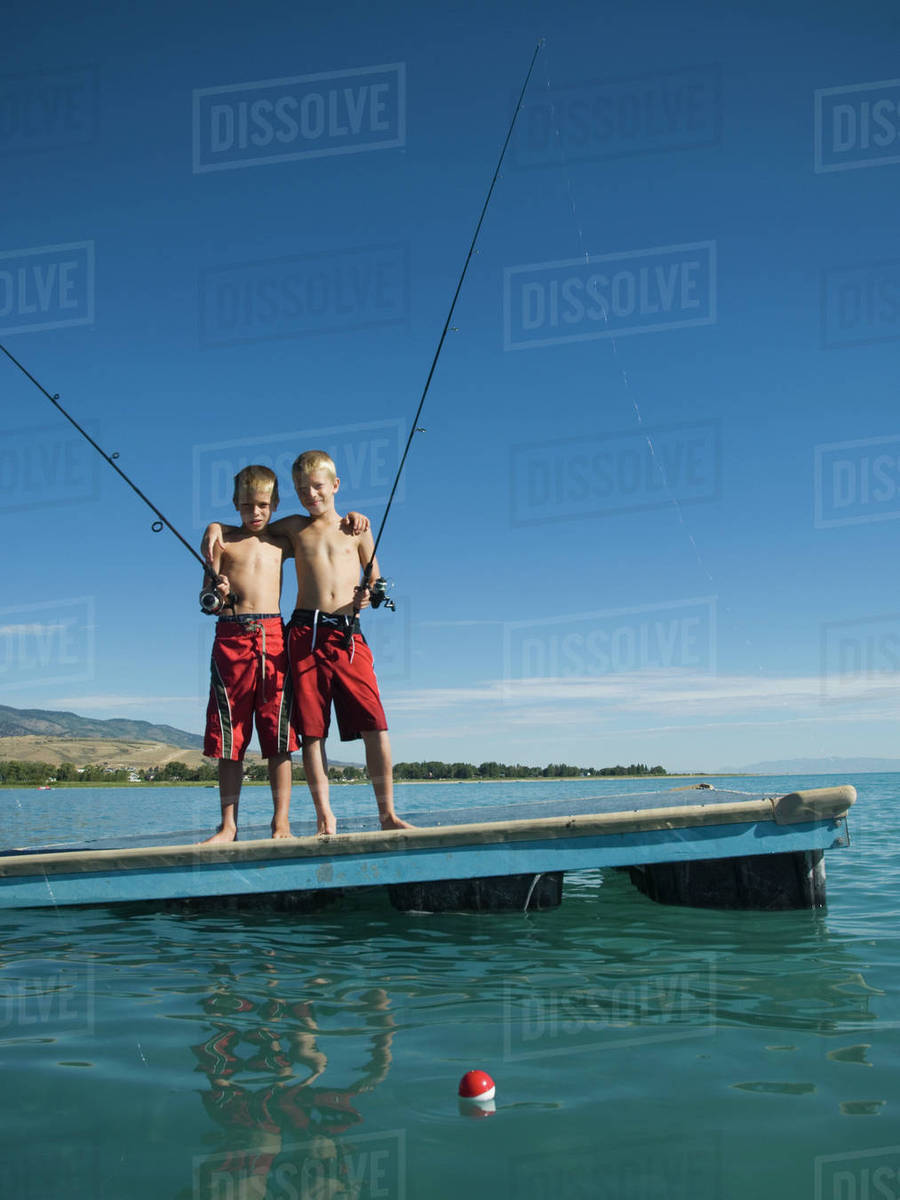 Brothers fishing off dock in lake, Utah, United States - Royalty-free ...