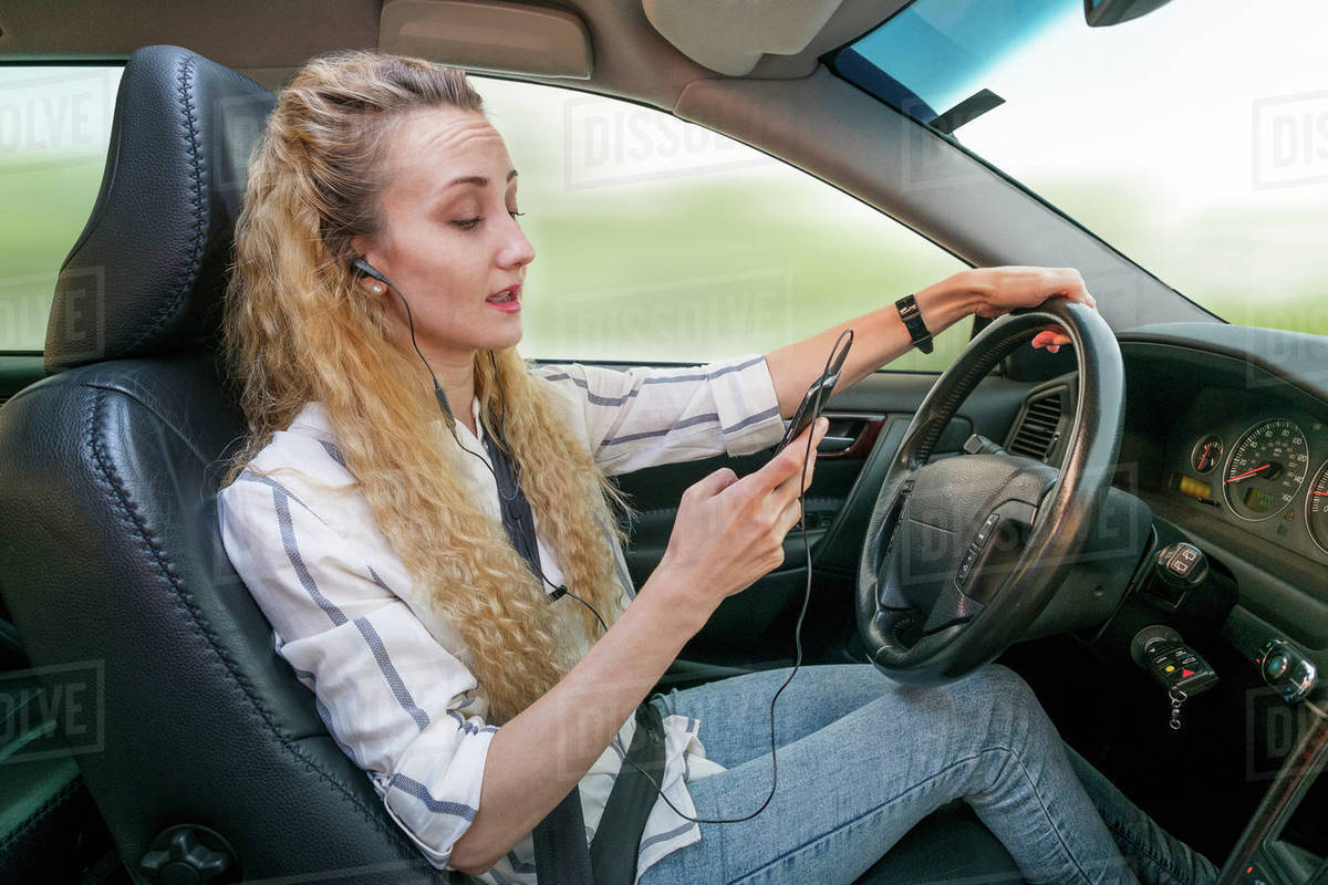 Woman using mobile phone during driving car - Royalty-free Stock Photo ...