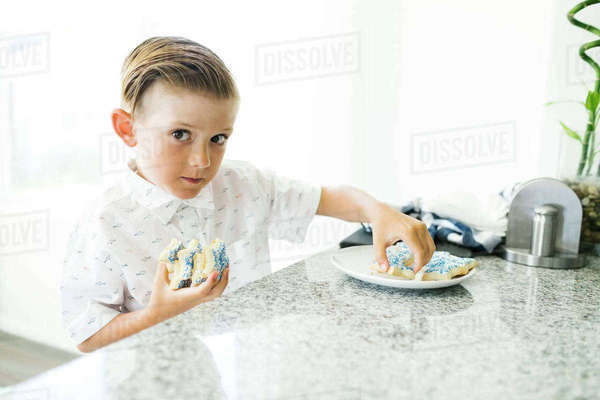 Boy (8-9) stealing cookies - Royalty-free Stock Photo | Dissolve