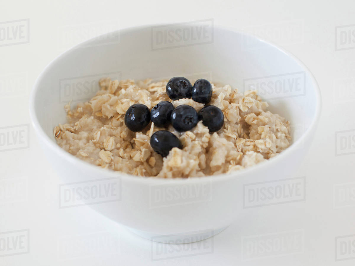 Oatmeal with blueberries on white background - Stock Photo - Dissolve