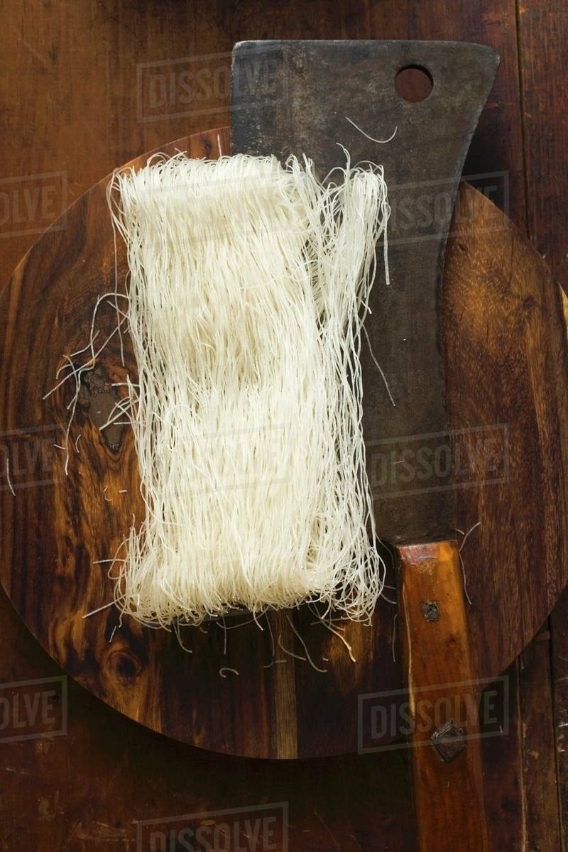 Thin rice noodles on wooden plate with Asian cleaver - Stock Photo ...