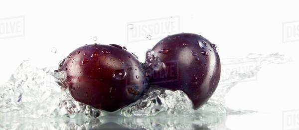 Two plums in water - Royalty-free Stock Photo | Dissolve