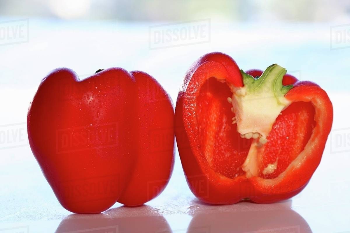 A whole and a halved red pepper - Royalty-free Stock Photo | Dissolve
