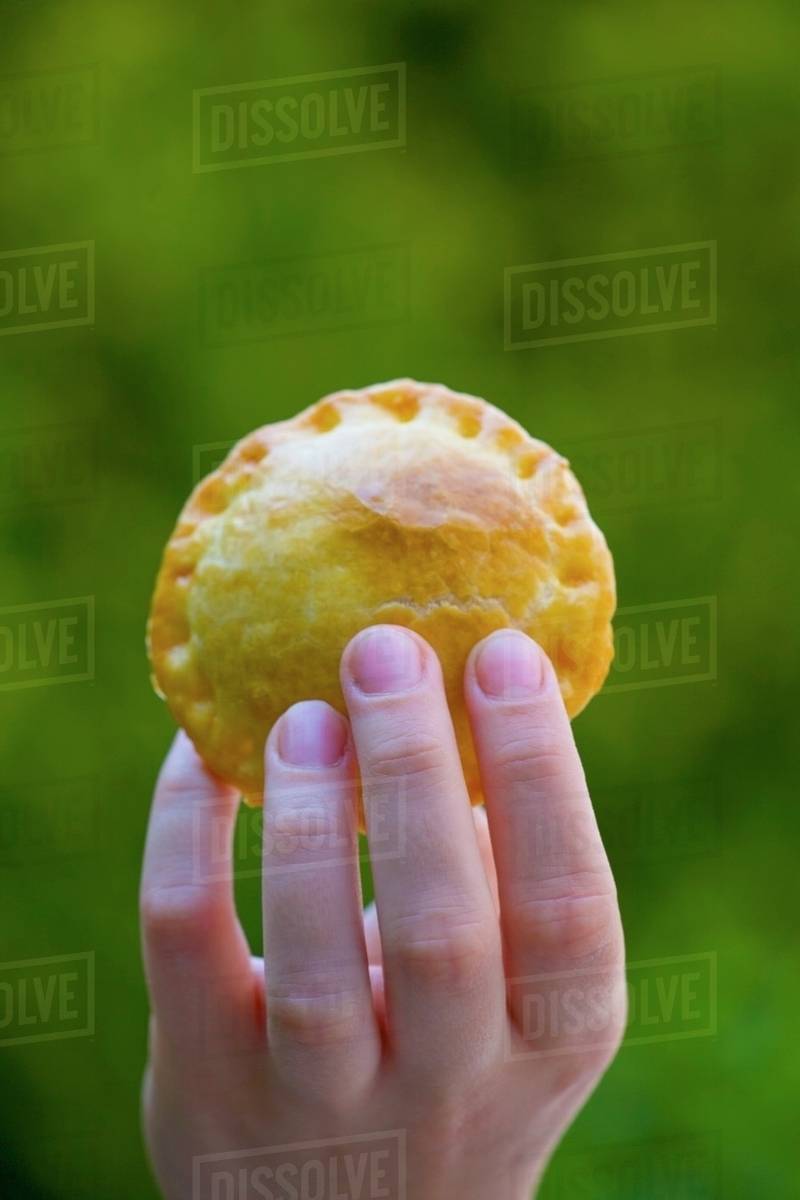 Hand holding meat pie - Royalty-free Stock Photo | Dissolve