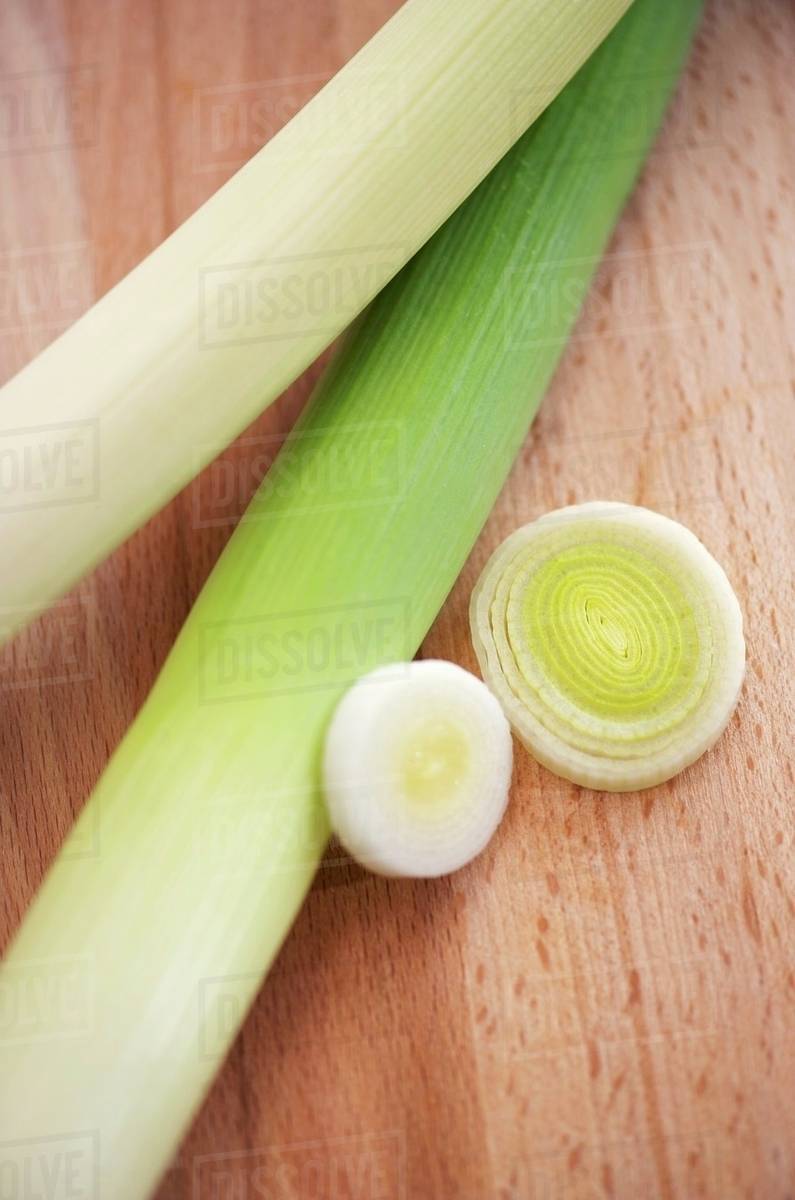 Leeks and leek rings on wooden background - Stock Photo - Dissolve