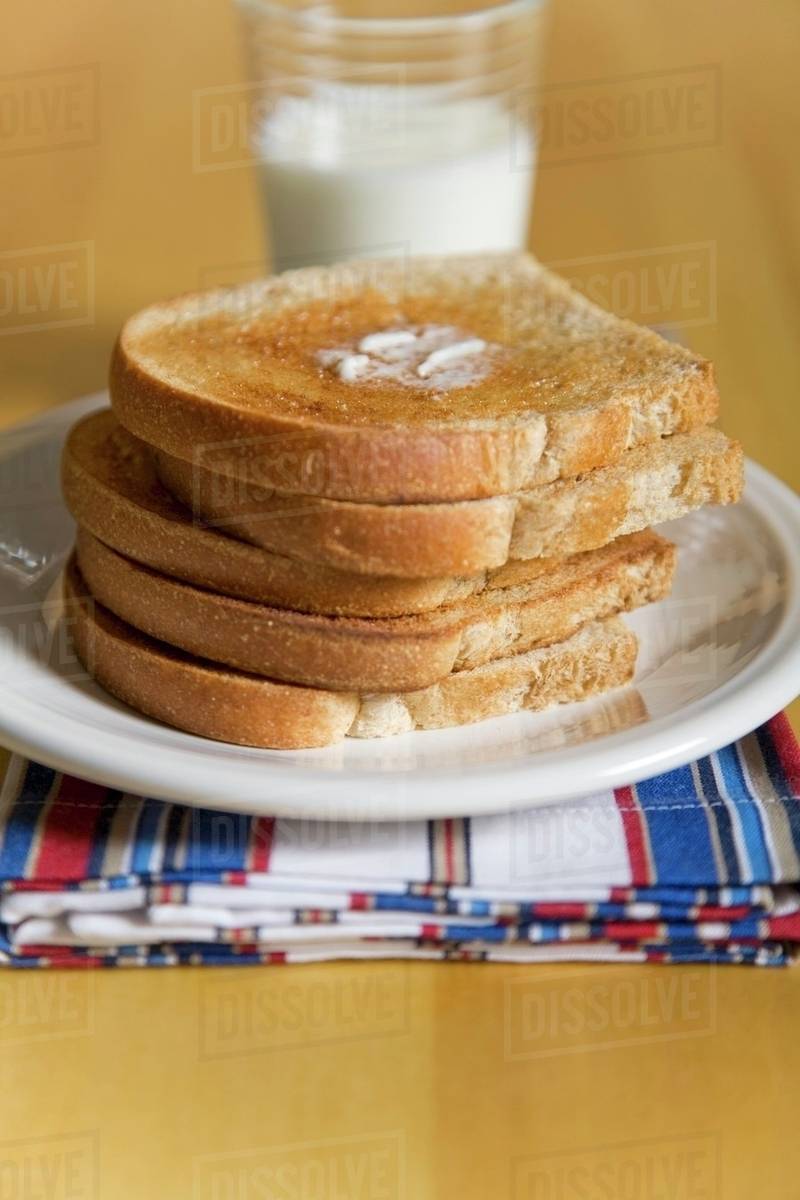 Stack of Buttered Toast on a White Plate; Glass of Milk - Royalty-free ...