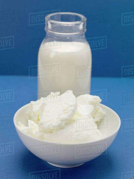 Quark in small white bowl in front of bottle of milk - Stock Photo ...