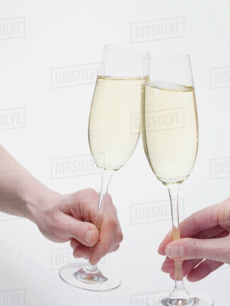 Hands clinking glasses of sparkling wine - Royalty-free Stock Photo | Dissolve
