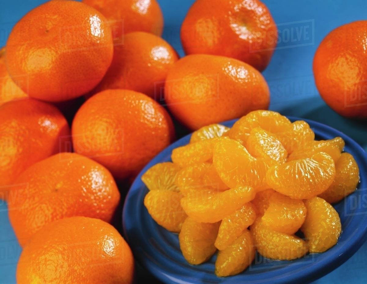 Blue Plate of Orange Segments with Whole Oranges - Royalty-free Stock ...