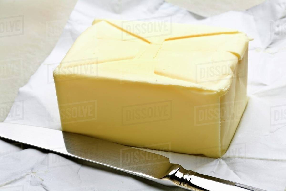 Block of butter on paper, knife beside it - Royalty-free Stock Photo ...