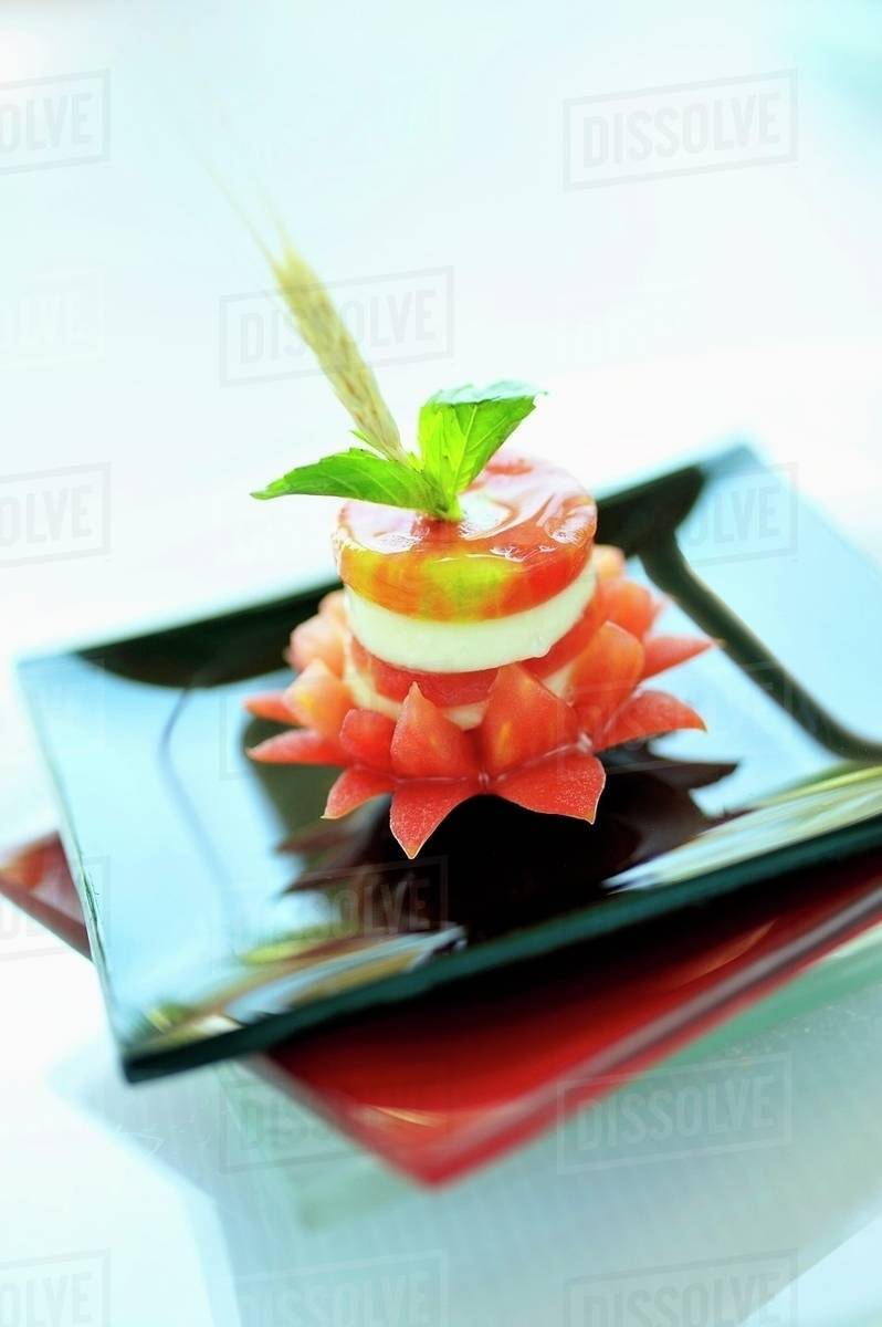 Tomato and mozzarella with carved tomato flower - Stock Photo - Dissolve