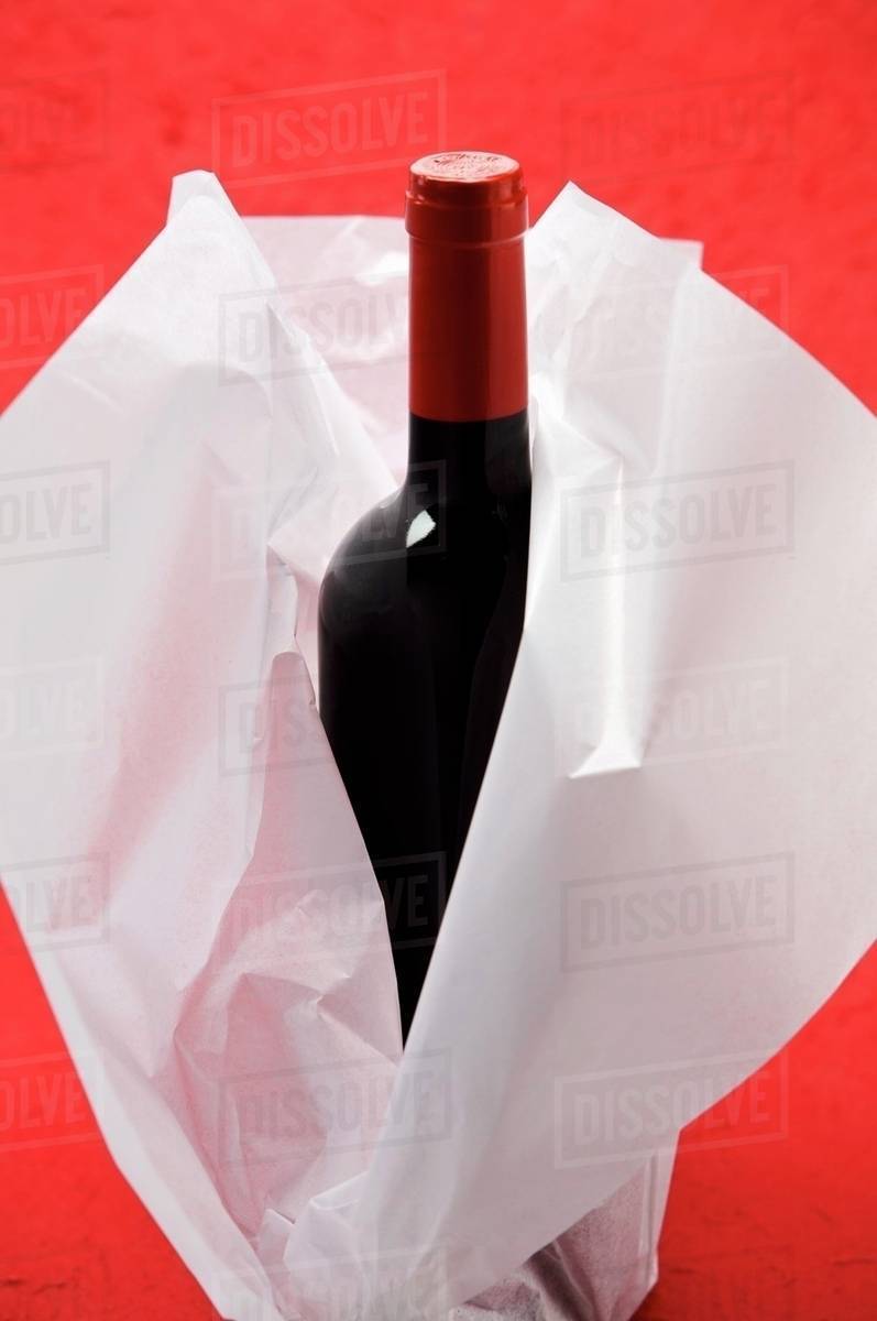 A Bottle Of Red Wine Wrapped In Tissue Paper Stock Photo Dissolve