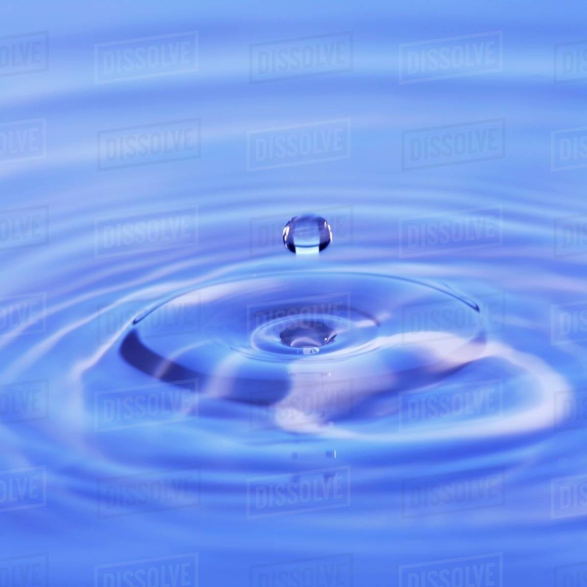 Drop of water falling into water - Royalty-free Stock Photo | Dissolve