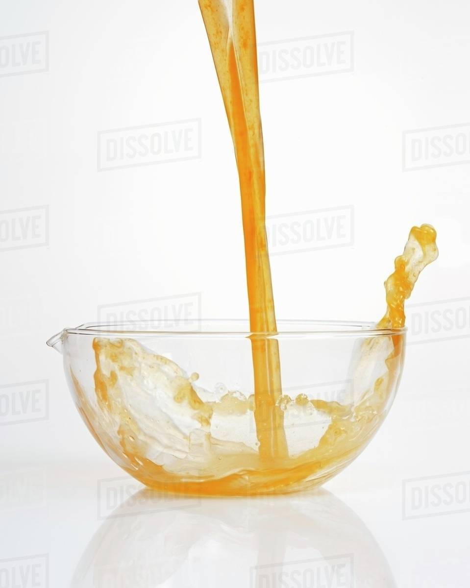 Pouring fruit juice into a glass bowl - Royalty-free Stock Photo | Dissolve