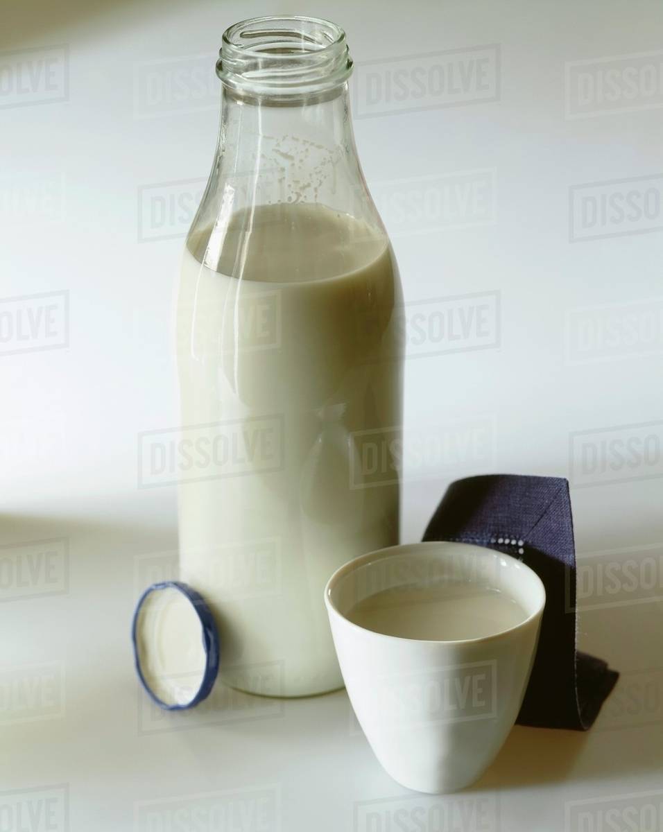 Milk in bottle and cup - Royalty-free Stock Photo | Dissolve