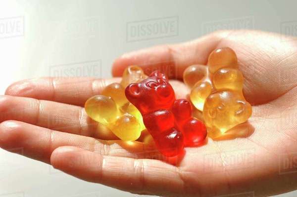Three gummi bears in someone's hand - Stock Photo - Dissolve
