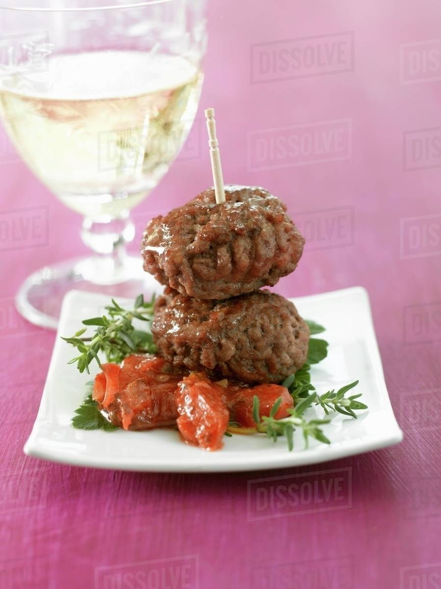 Two meatballs on tomato with herbs - Stock Photo - Dissolve