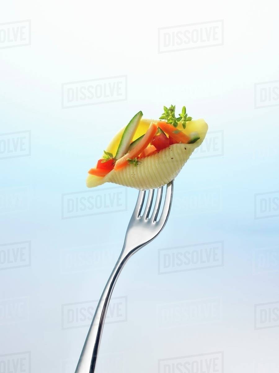 Pasta shell filled with vegetables on a fork - Stock Photo - Dissolve