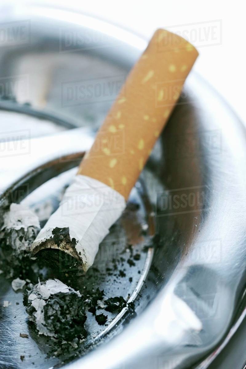 Cigarette end in an ashtray - Stock Photo - Dissolve