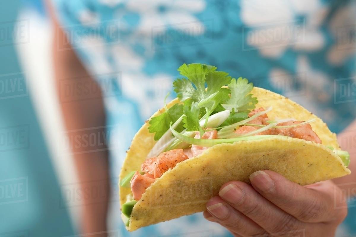 Woman holding taco - Stock Photo - Dissolve