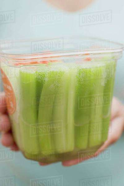 Woman holding plastic container of celery and carrots - Royalty-free ...