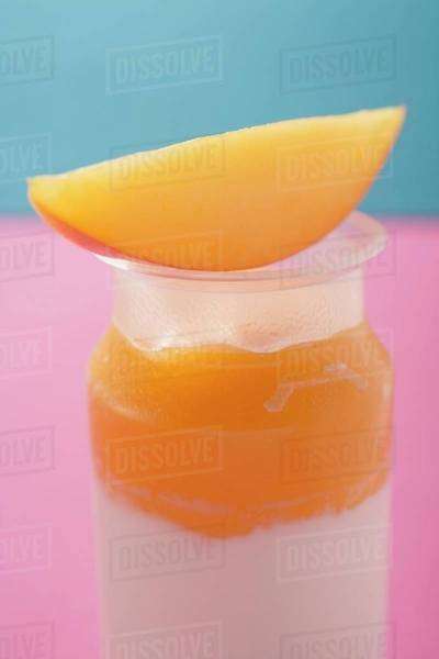 Mango yoghurt with wedge of mango - Royalty-free Stock Photo | Dissolve