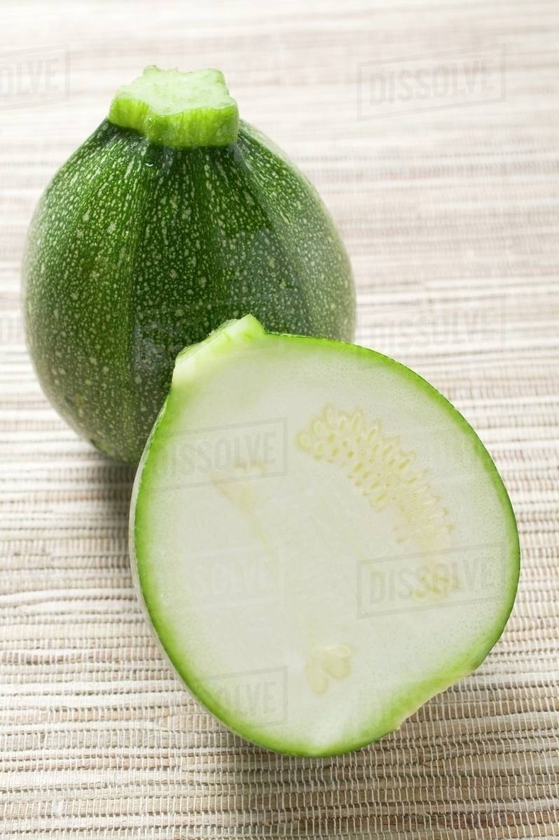 Round courgettes, whole and halved - Royalty-free Stock Photo | Dissolve
